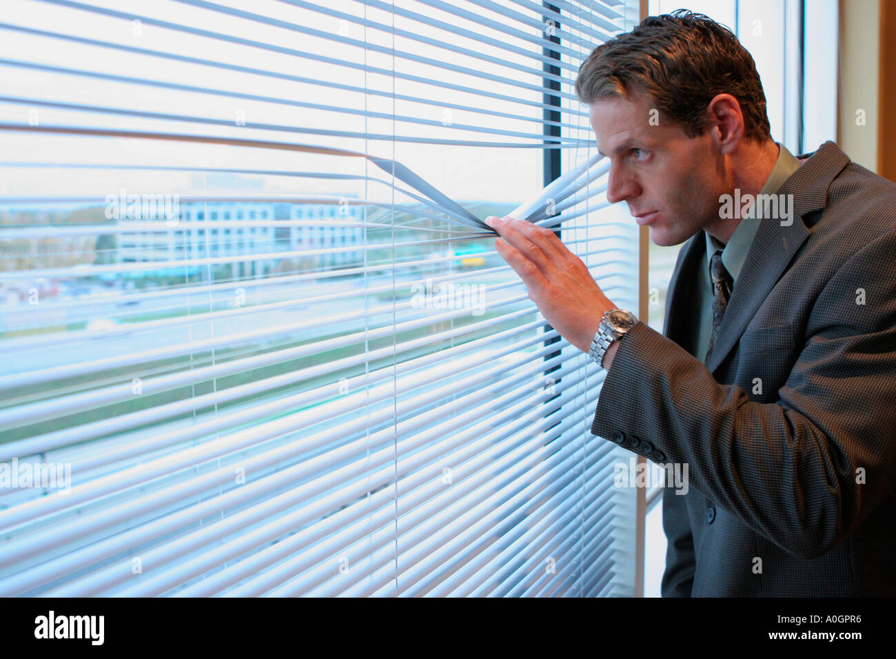 Side profile of a businessman looking through a window Stock Photo - Alamy