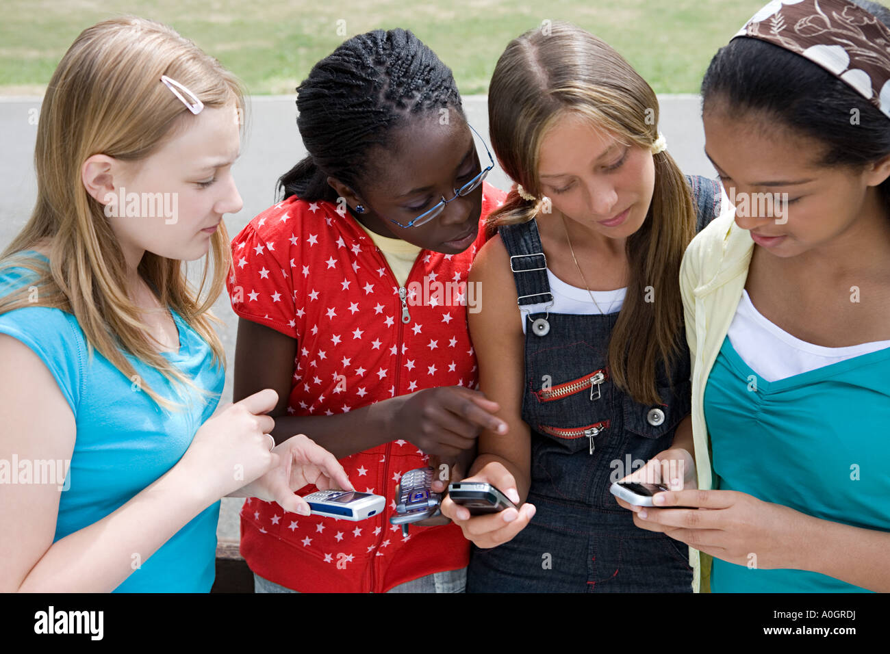 Girls row looking at mobile phones hi-res stock photography and images ...