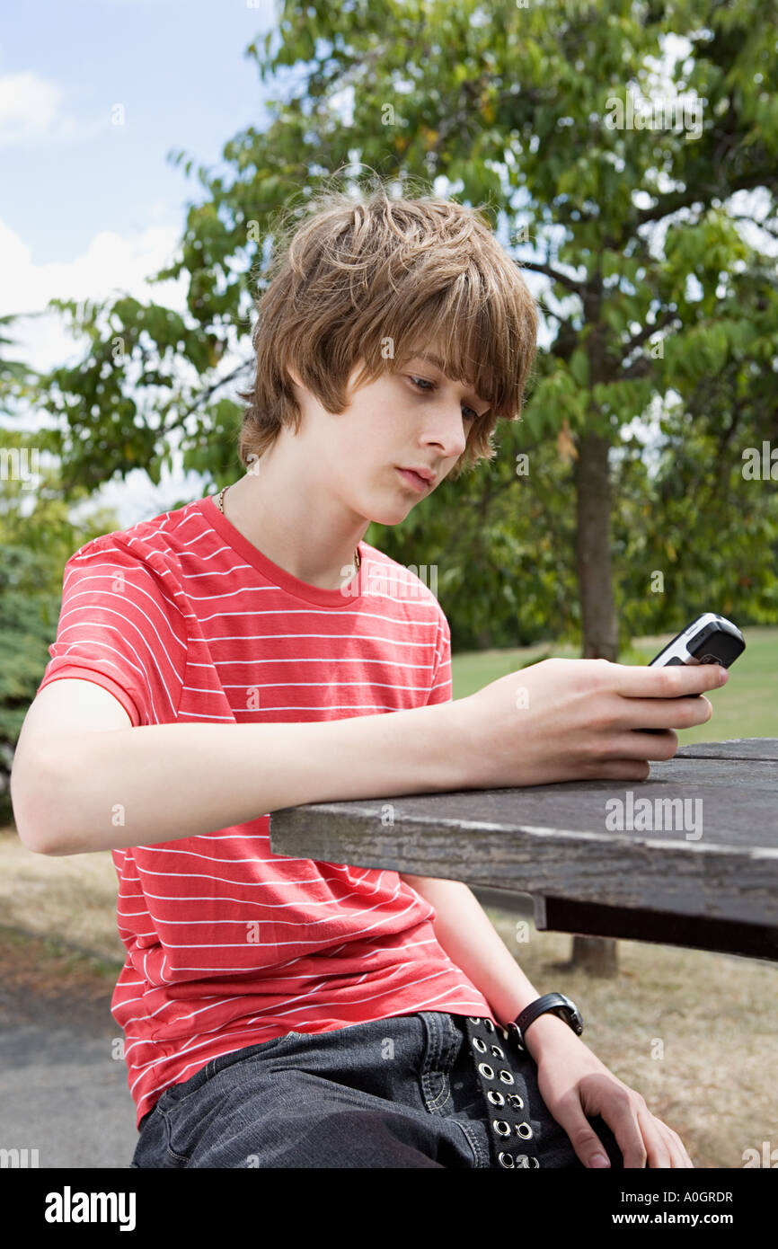 Teenage boy looking at cellphone Stock Photo - Alamy