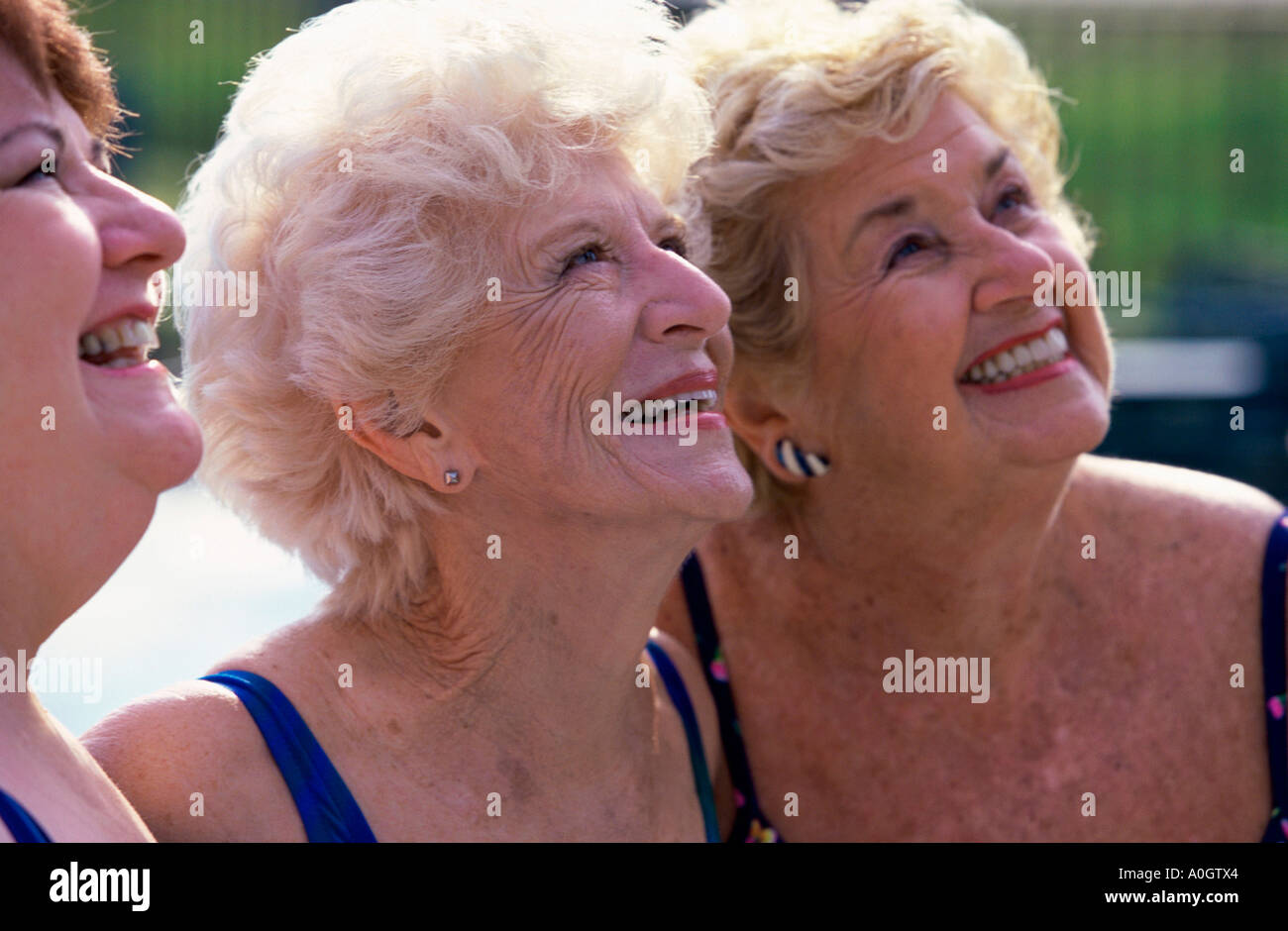 Three women looking up smiling Stock Photo - Alamy