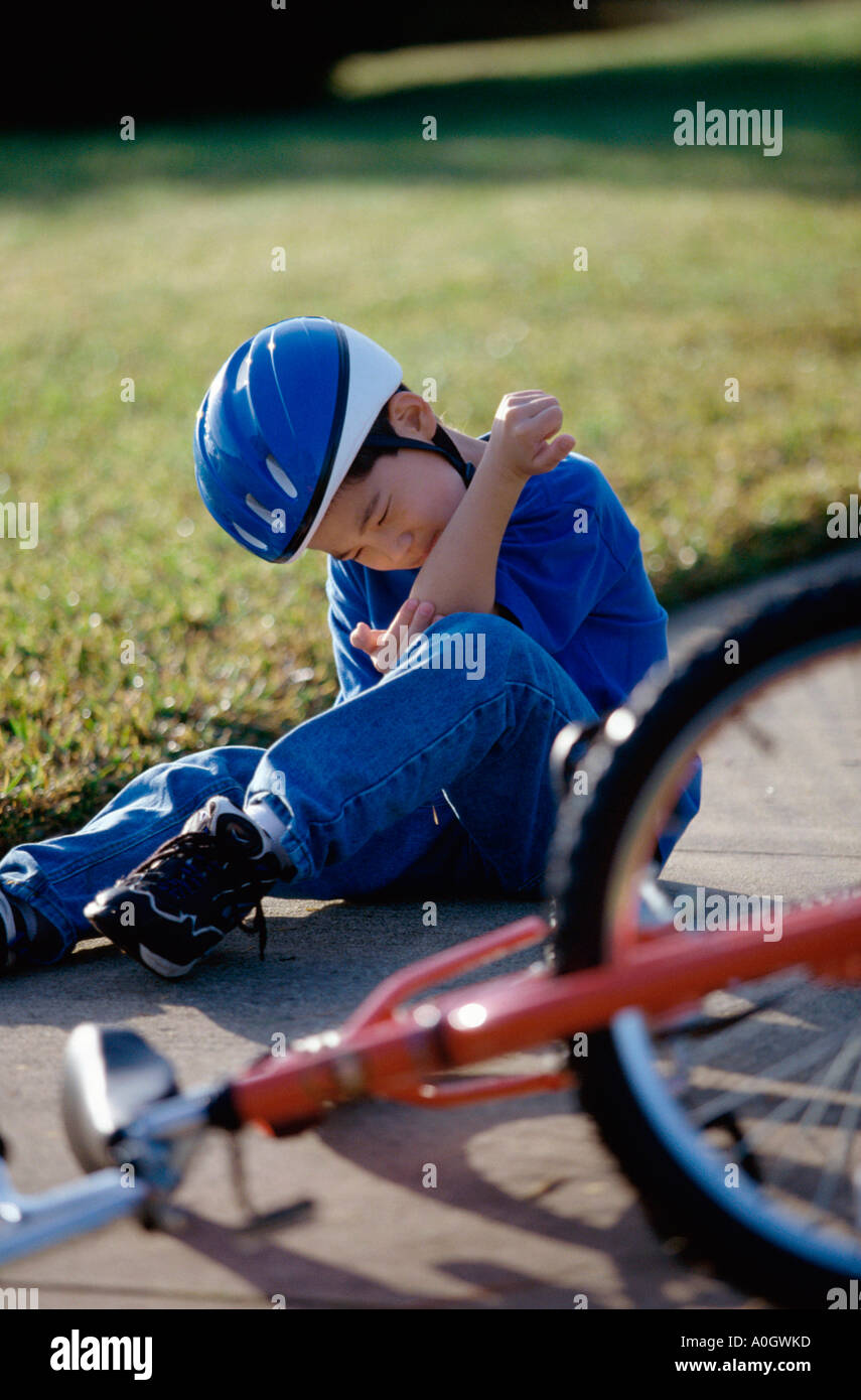 Boy fallen from a bicycle holding his injured elbow Stock Photo - Alamy