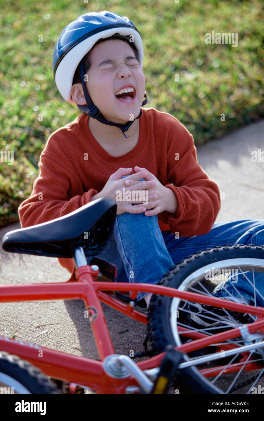 Boy fallen from a bicycle holding his injured knee Stock Photo - Alamy