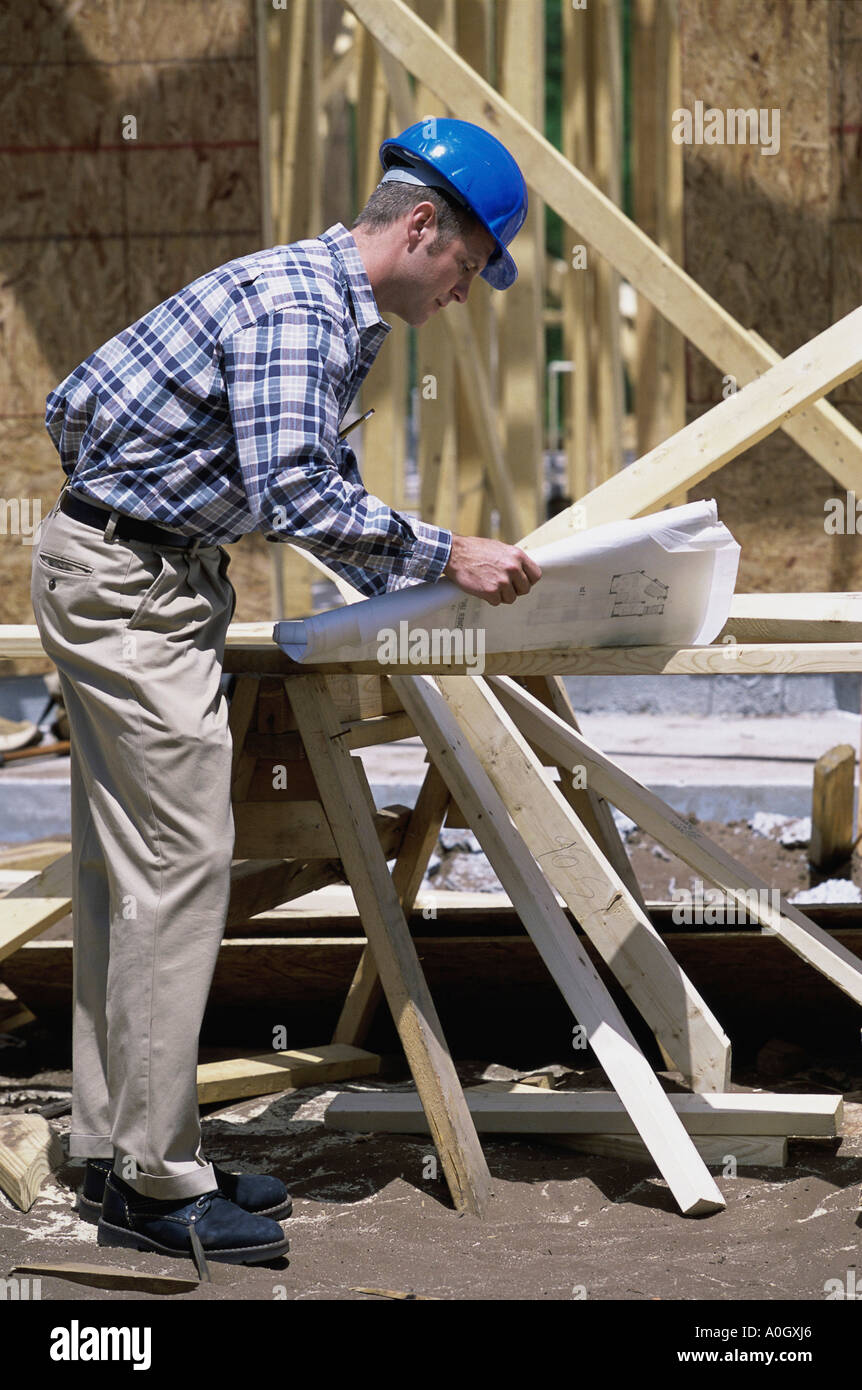 Foreman standing at a construction site holding blueprints Stock Photo ...