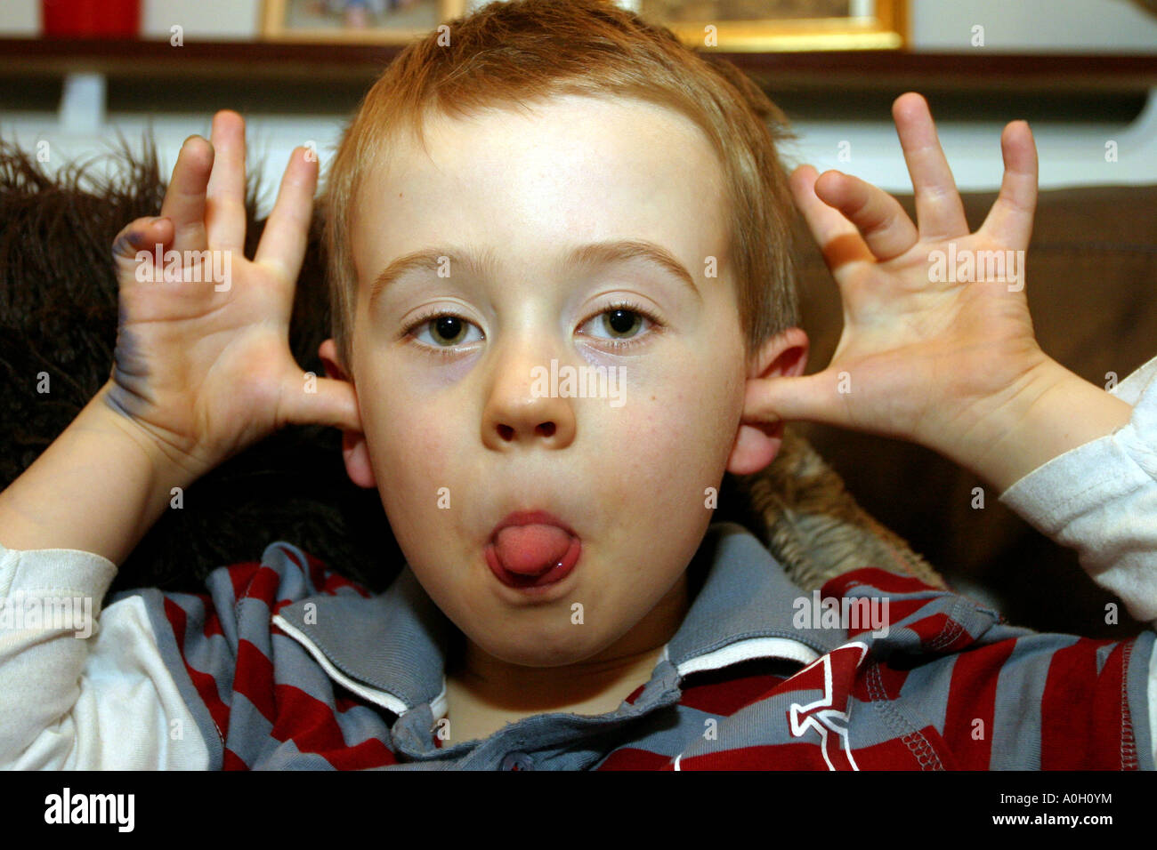 child pulling silly face Stock Photo - Alamy