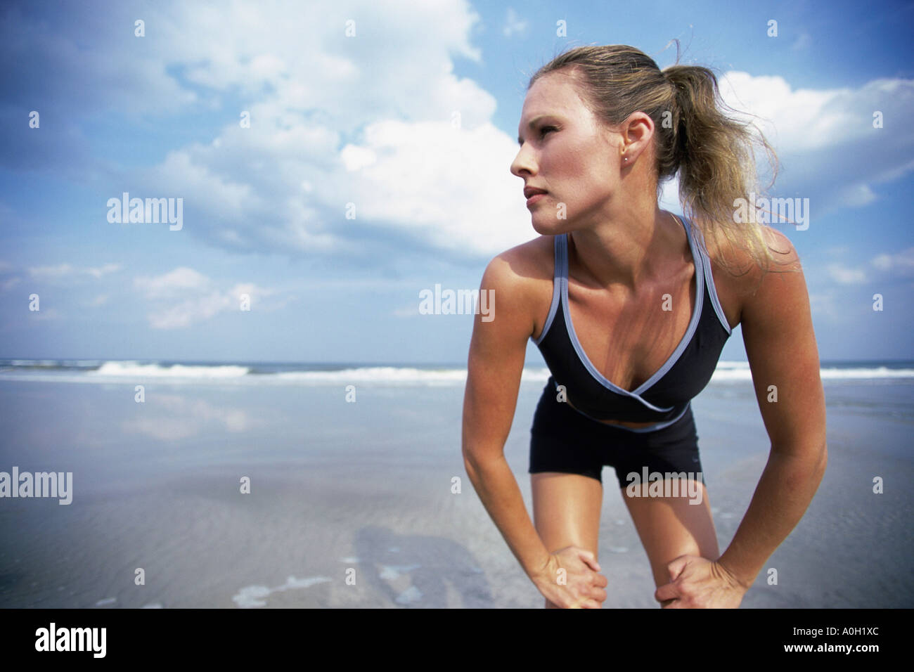 Low angle view of a young woman bending forward on the beach Stock ...