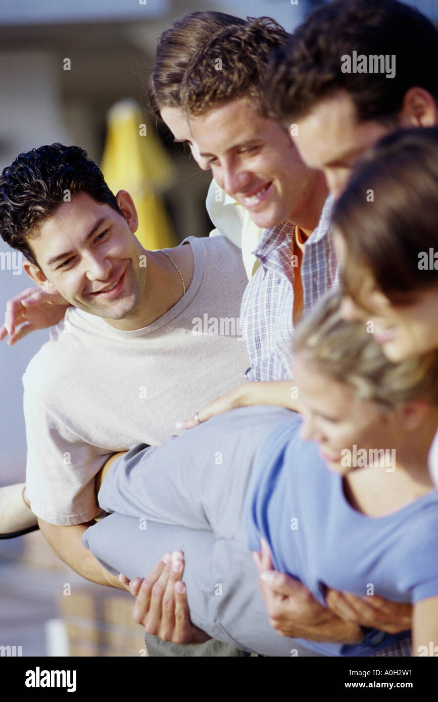 Group of young men carrying a young woman Stock Photo - Alamy