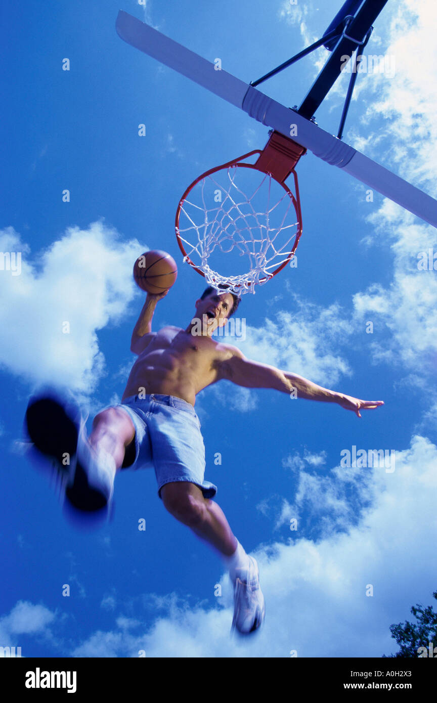 Low angle view of a young man slam dunking a basketball Stock Photo - Alamy