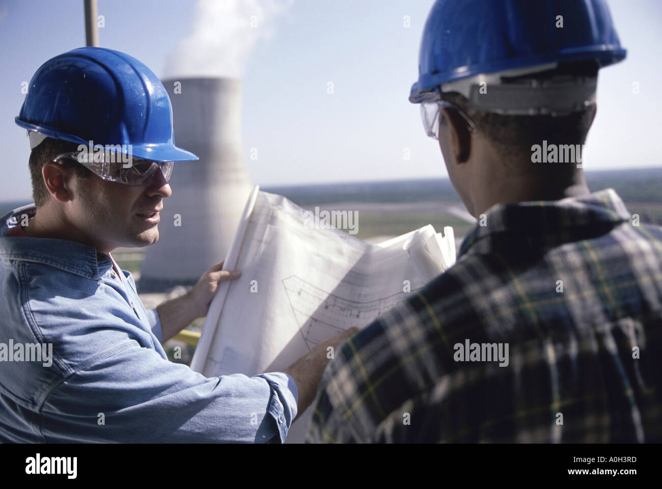 Two workers looking at blueprints Stock Photo - Alamy