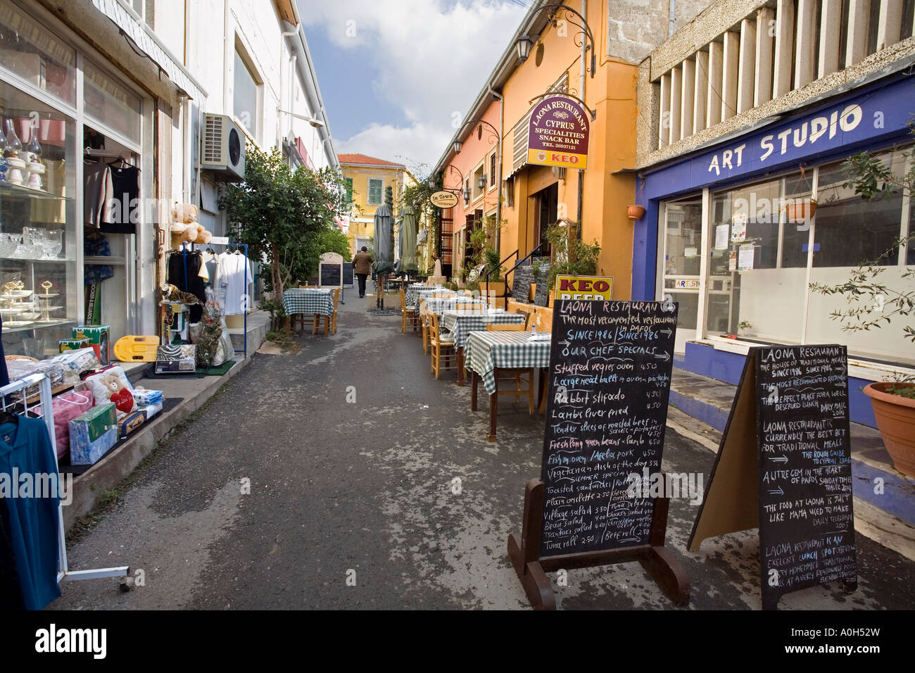 A TYPICAL NARROW STREET WITH TABLES AND CHAIRS OUTSIDE A RESTAURANT IN ...