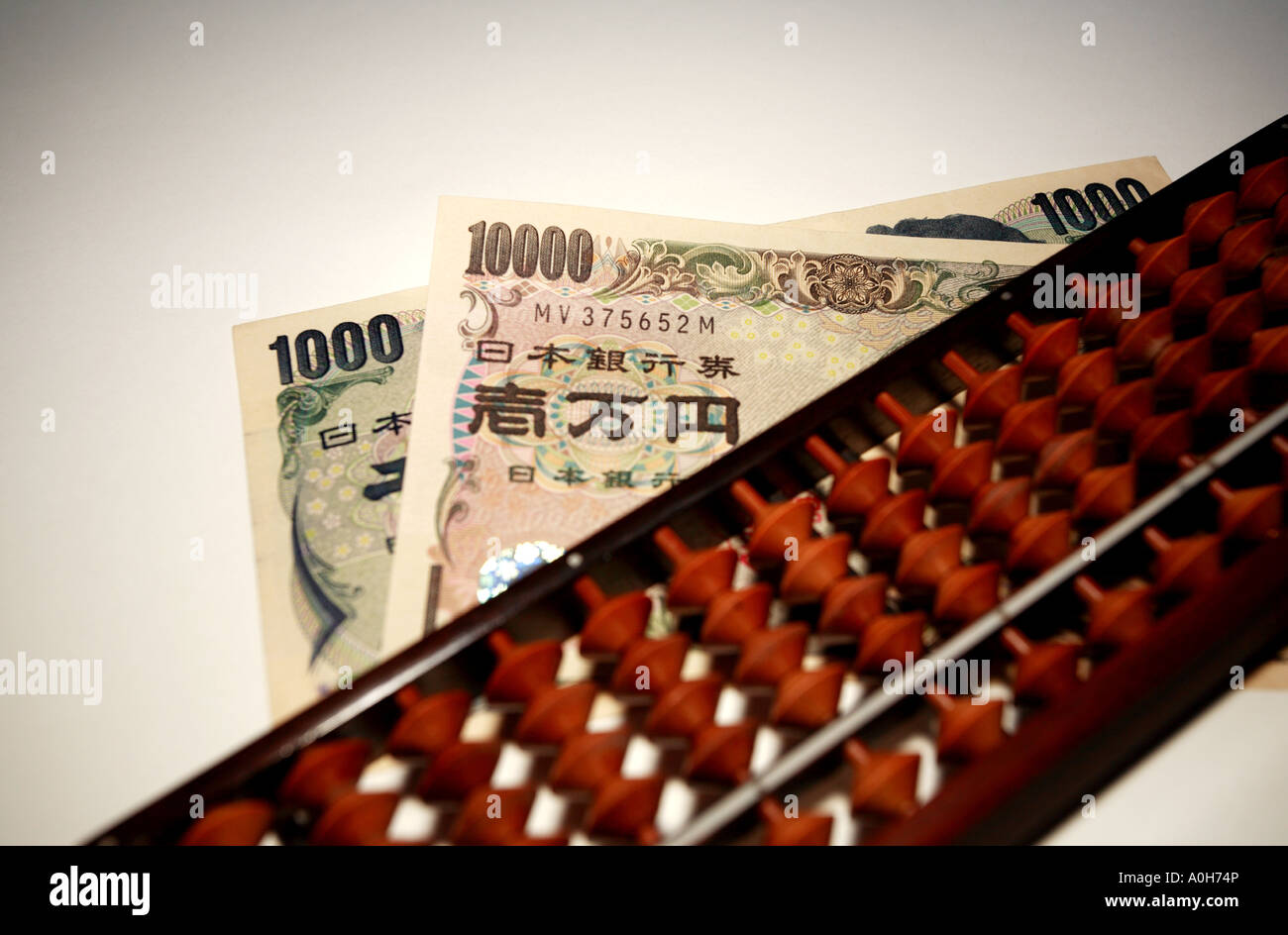 Wooden Japanese abacus and yen on white background Stock Photo - Alamy