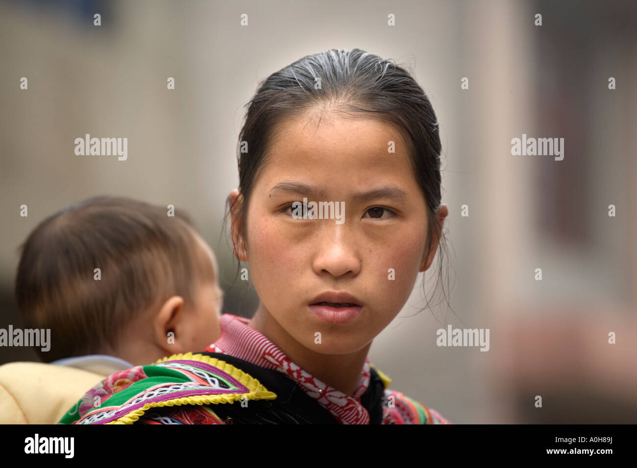 Young Yi minority woman with baby, Xinjie village market, Yuanyang, Yunnan, China Stock Photo ...