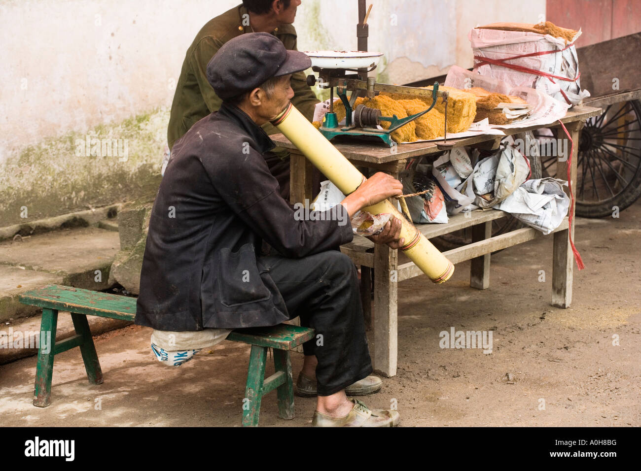 Mature man smokes a bong of tobacco at Shengcun market, Yuanyang ...
