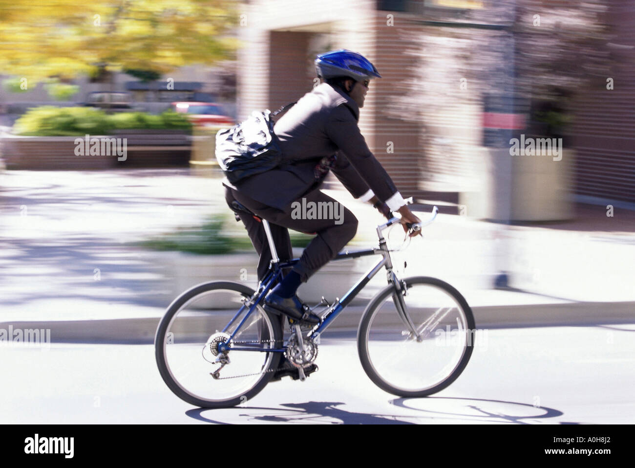 Side profile of a businessman riding a bicycle Stock Photo - Alamy