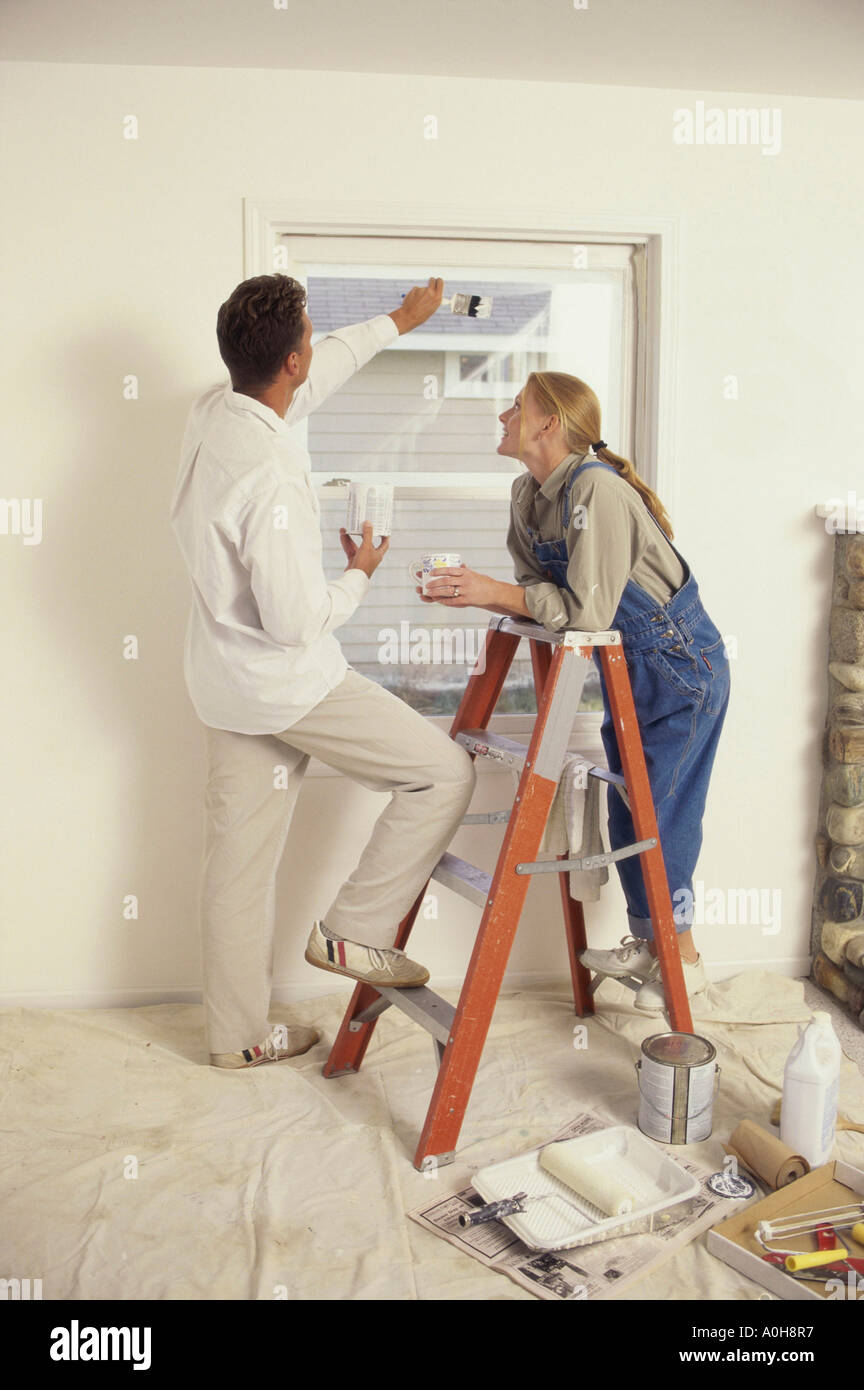 Young couple standing on a ladder Stock Photo - Alamy