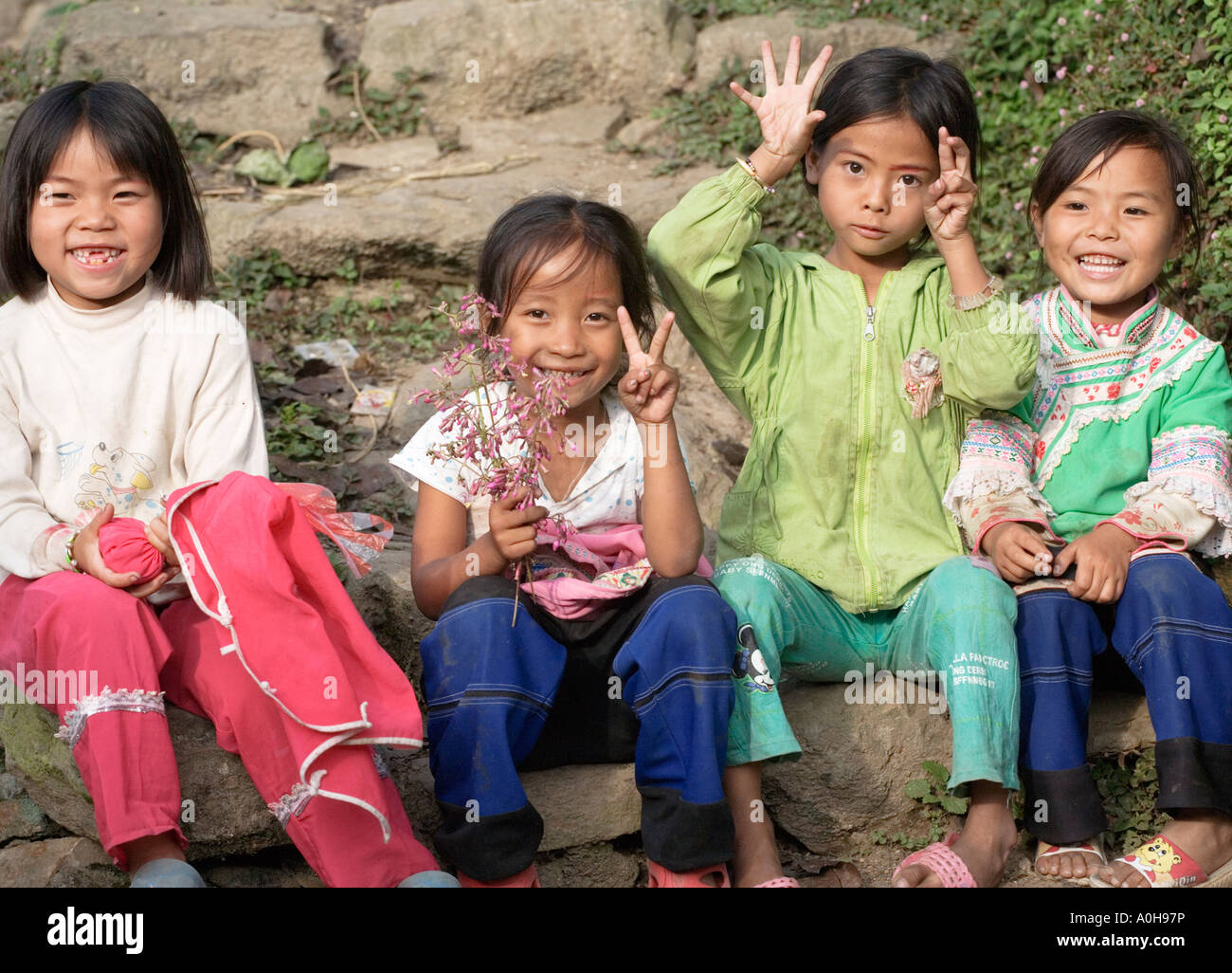 Four young Chinese minority girls sitting and playing, Jin Zhu Zhai ...