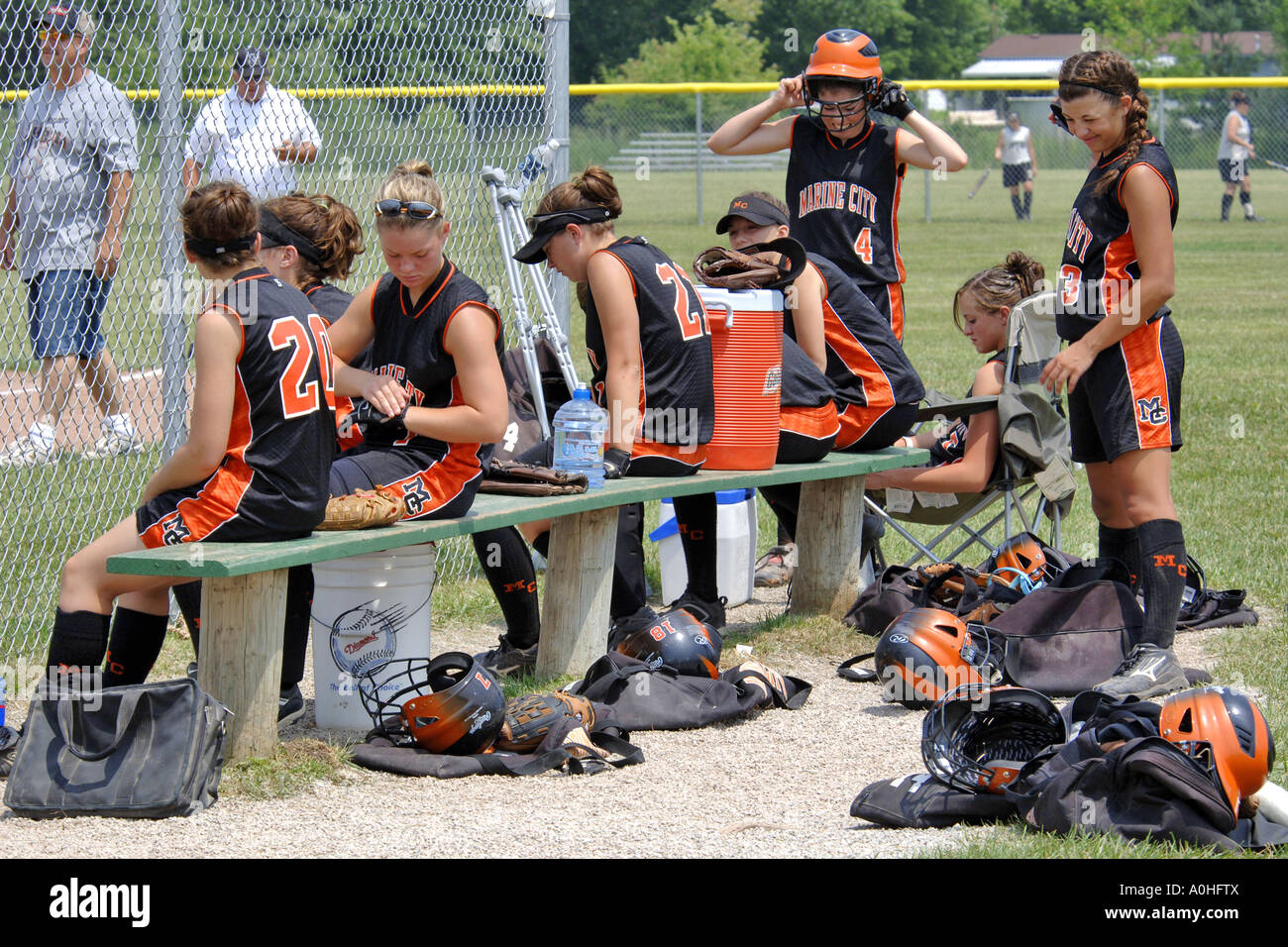 Teenage female major league Softball players sitting on the bench Stock ...