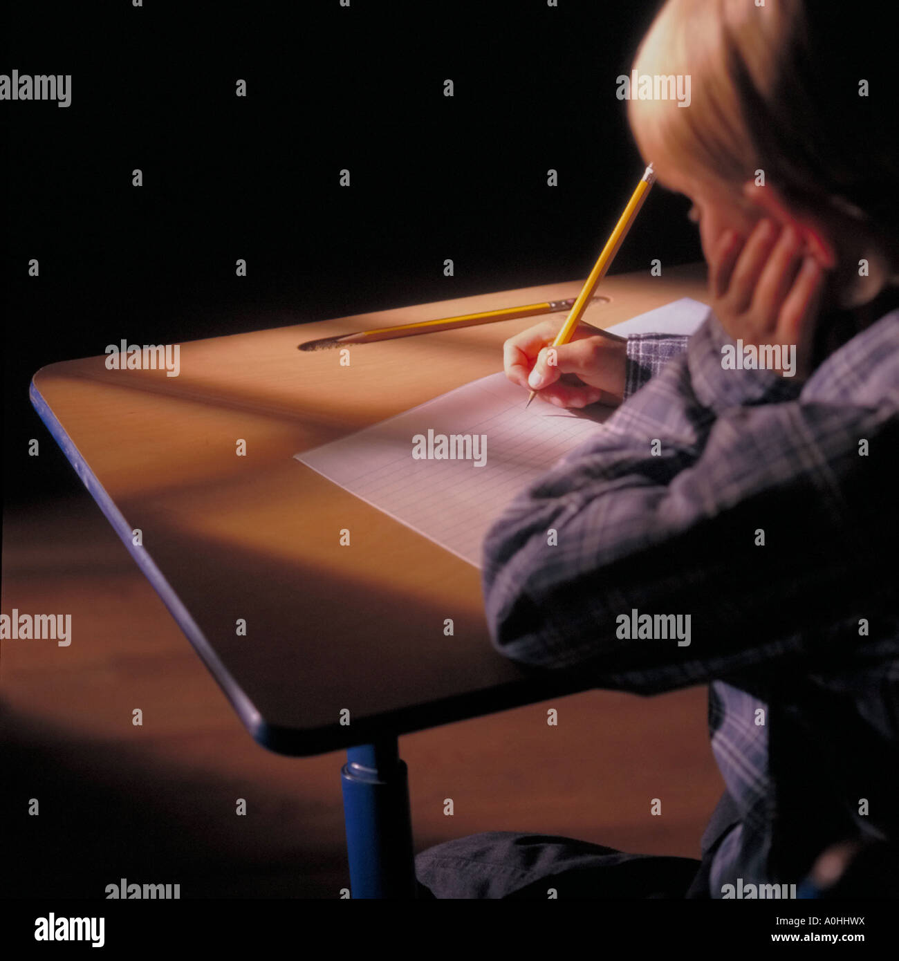 young boy writing at desk Stock Photo - Alamy