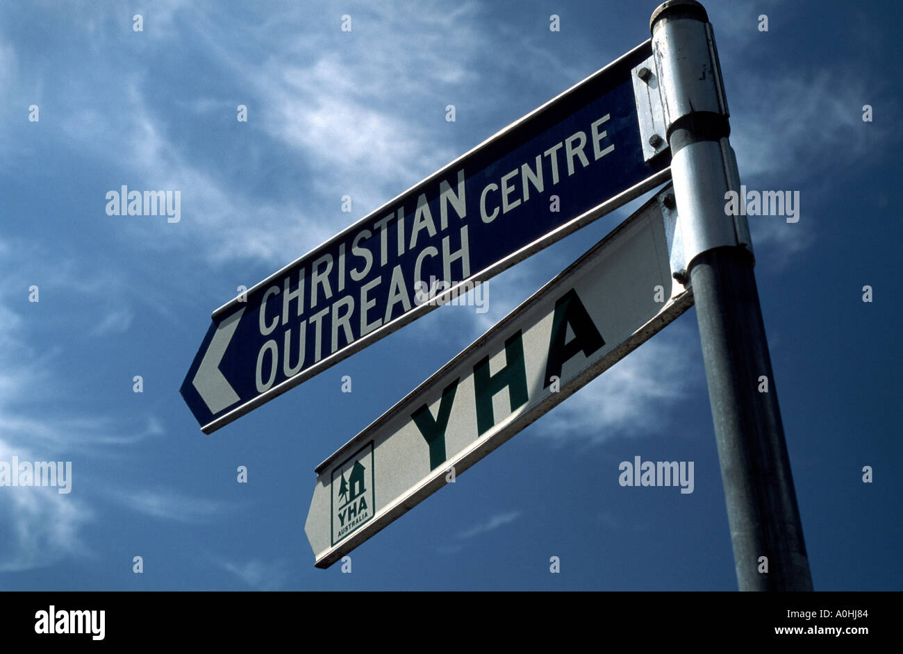 Christian Outreach and YHA street signs against a blue sky backdrop ...