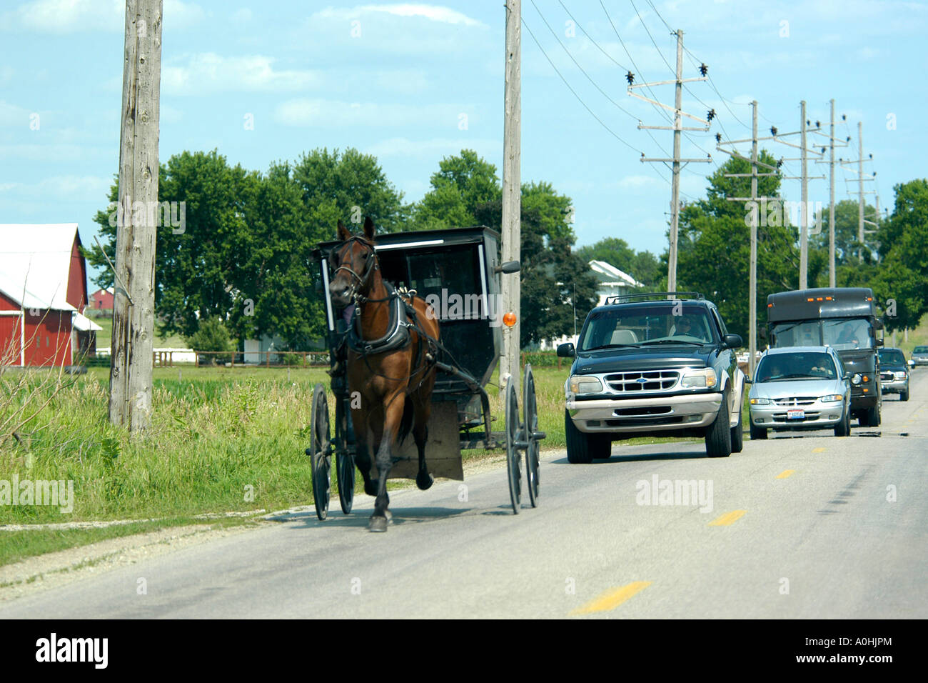 Amish family riding in a horse drawn buggy along the main highway in ...