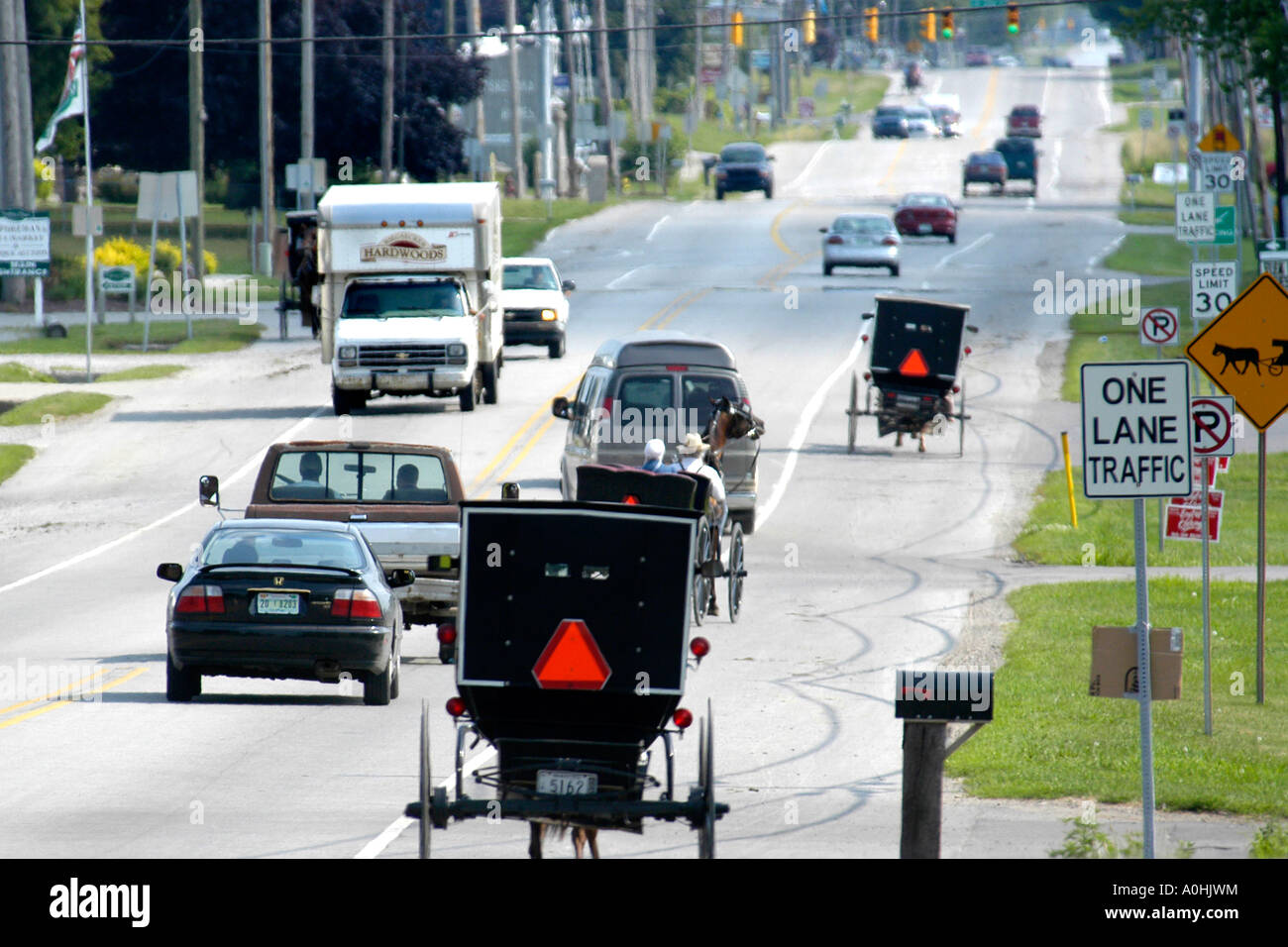 Amish people riding in the horse and buggy along an Indiana highway ...