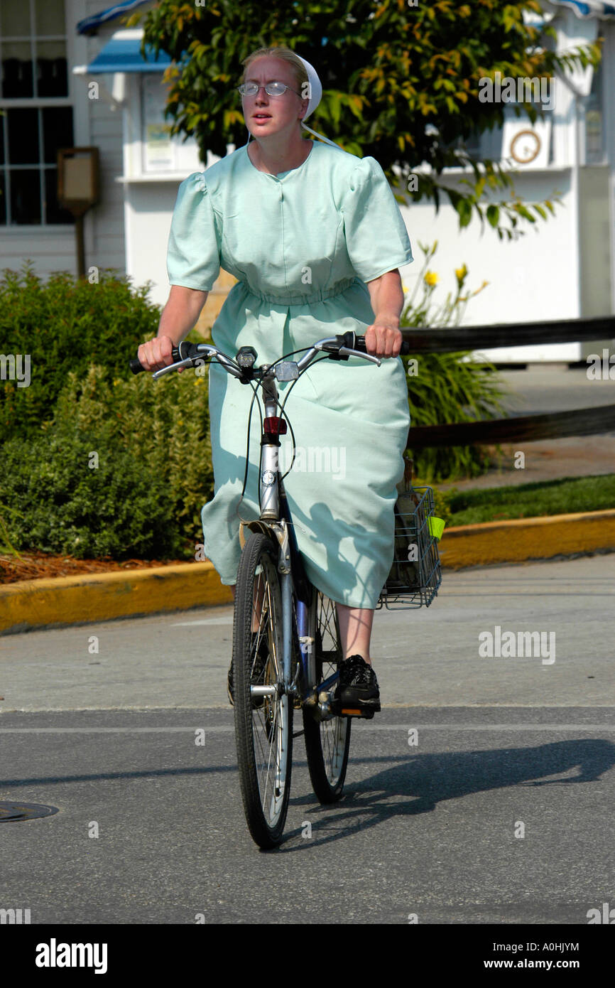 Amish young woman wearing tradiional clothing riding a bicycle in ...
