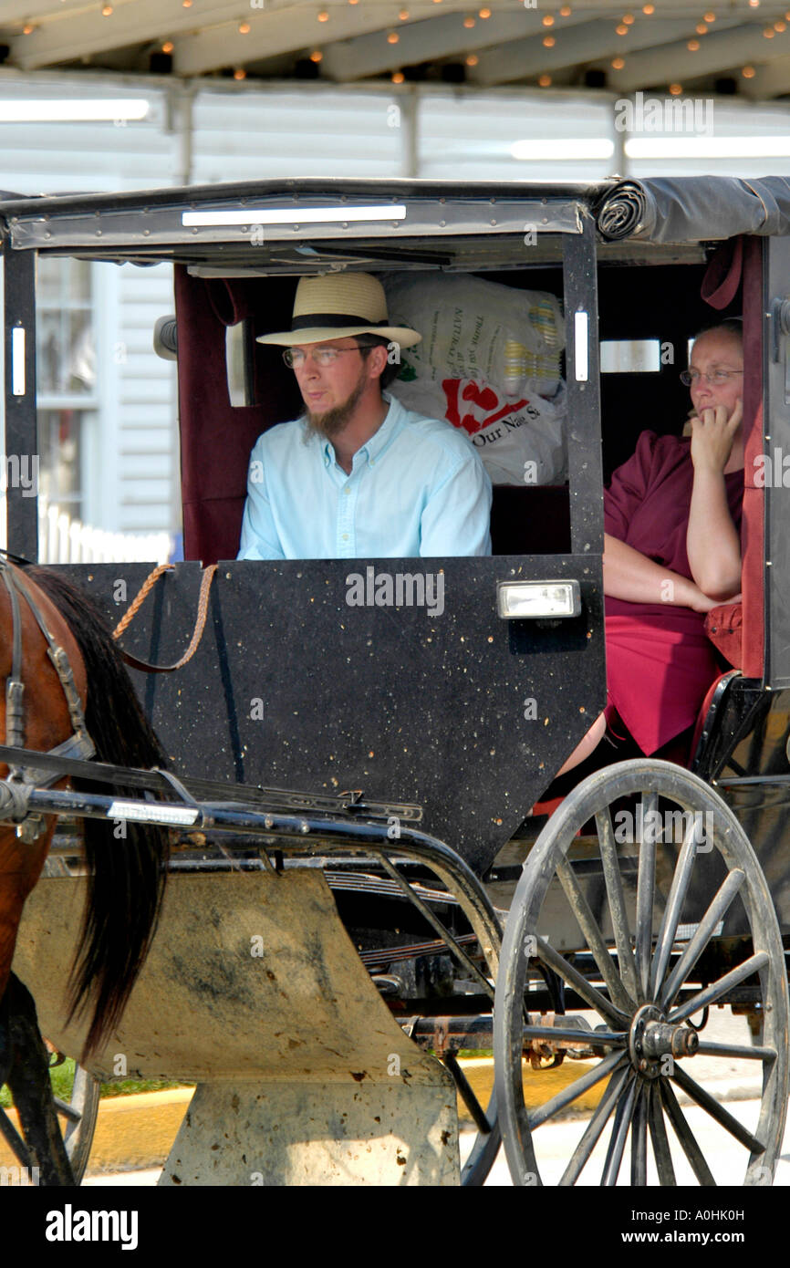 Amish couple riding in a horse drawn buggy in Shipshewana, Indiana ...