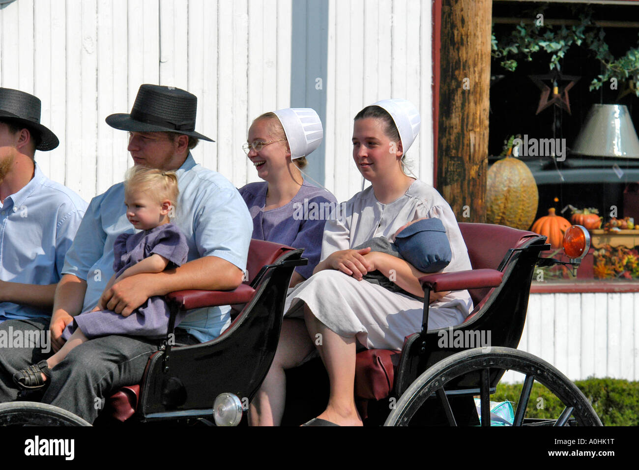 Amish family riding in an open horse drawn buggy in Shipshewana ...