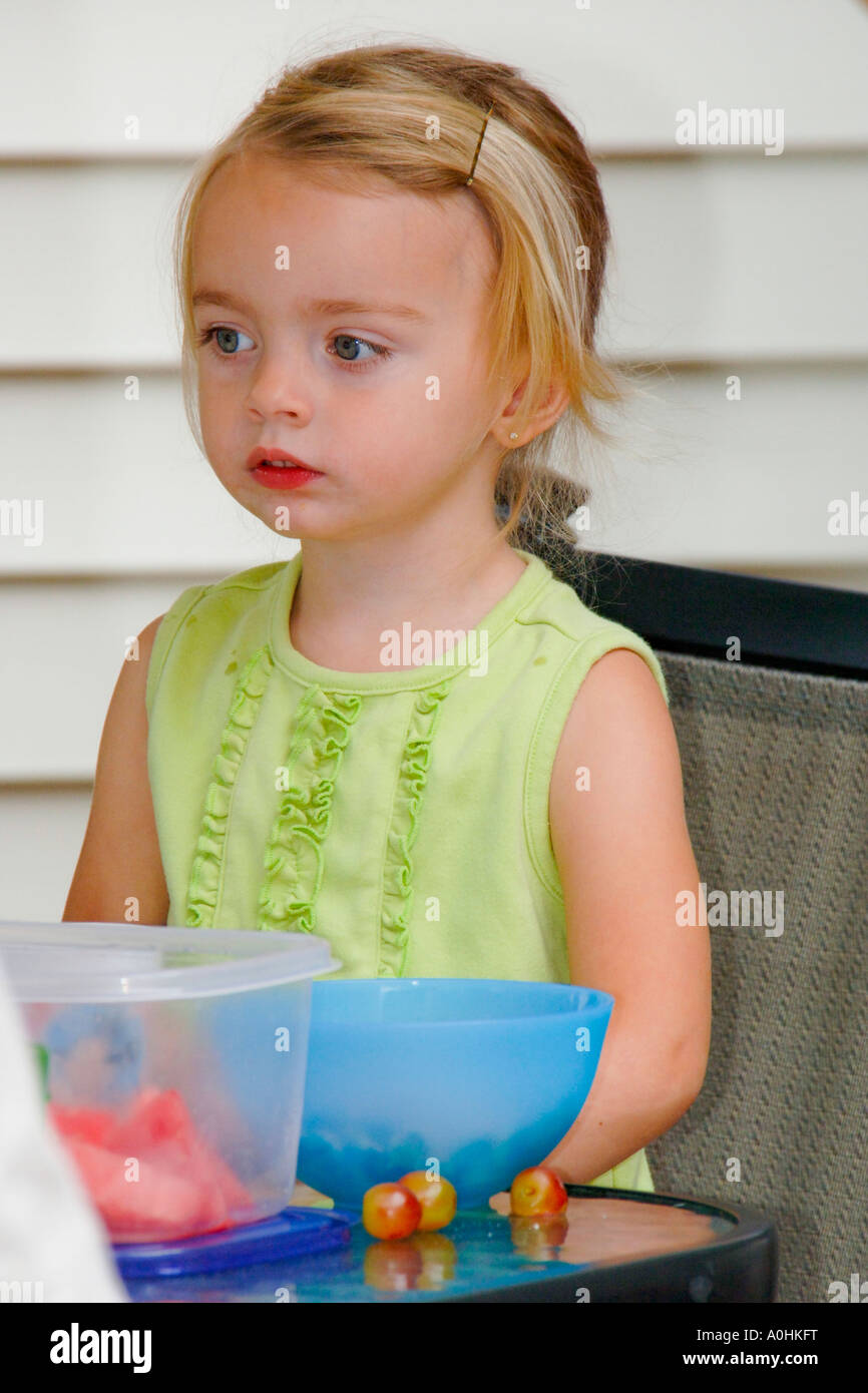 Cute Pre-K female with blonde hair sitting at a table Stock Photo - Alamy