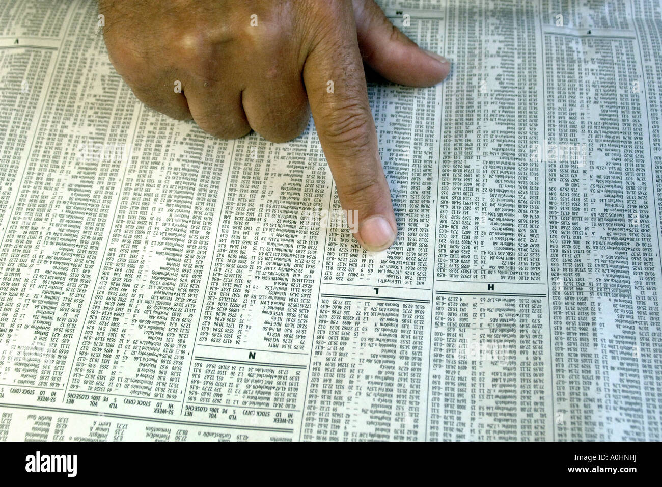 Using a finger as a ruler as this man checks out the share prices Stock ...