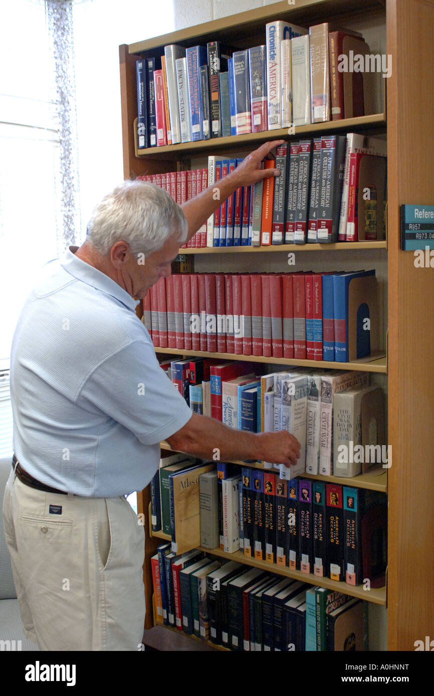 An adult male searching for a reference book in a Library Stock Photo ...