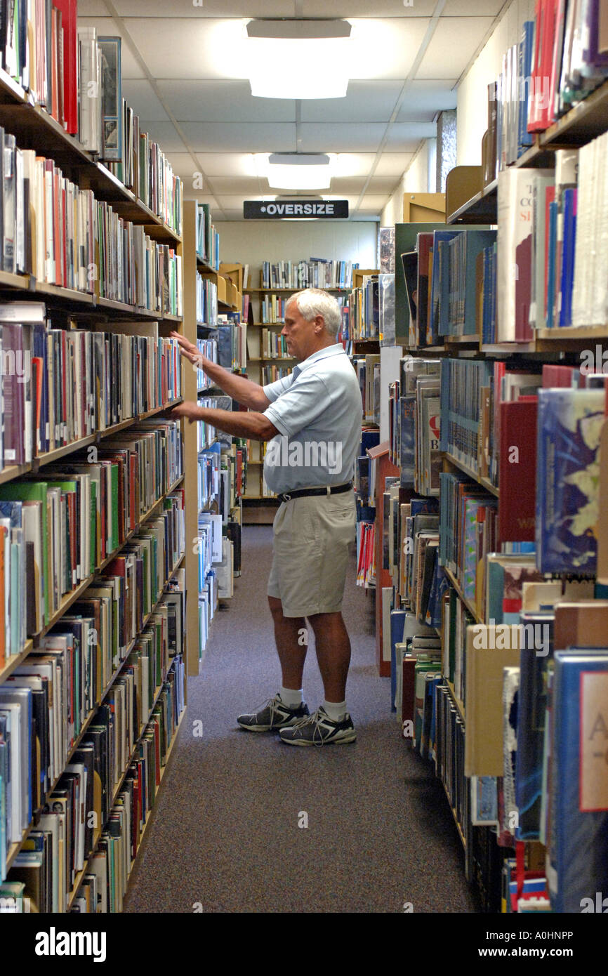 An adult male searching for a reference book in a Library Stock Photo ...