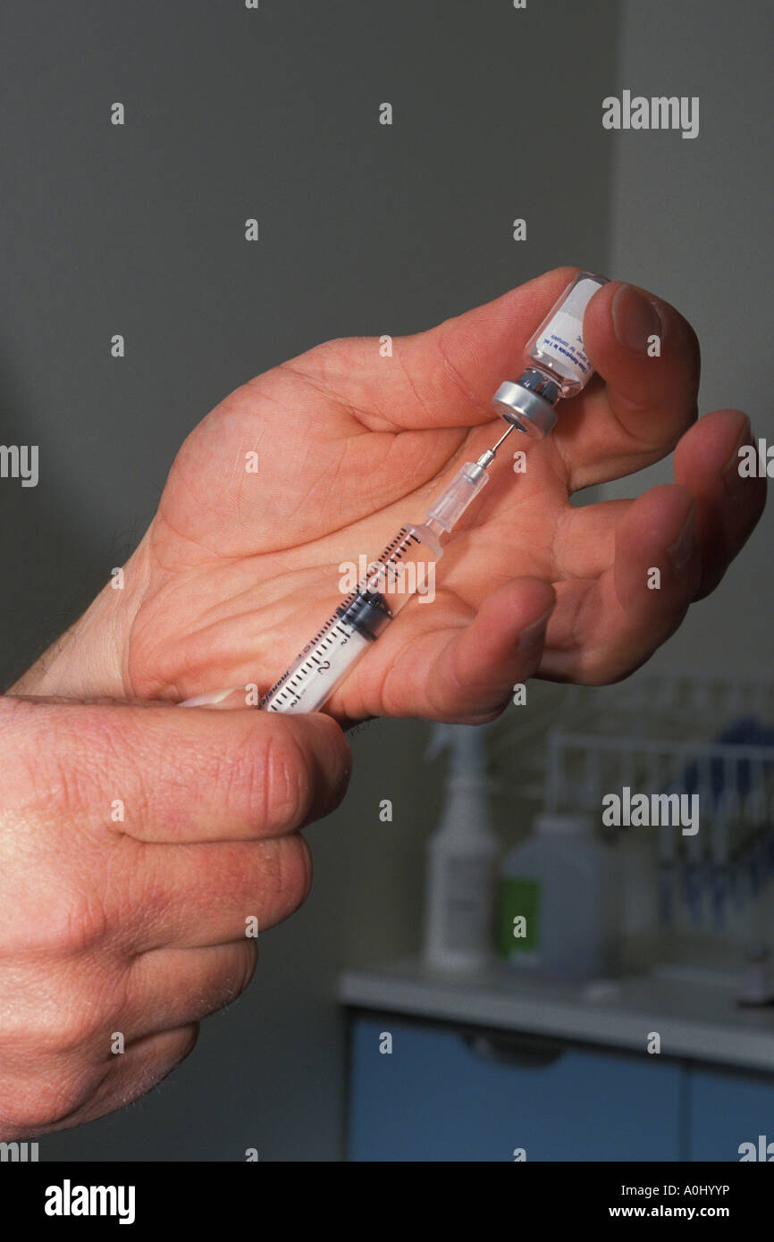 Veterinarian loading medicine into syringe from vial Stock Photo - Alamy