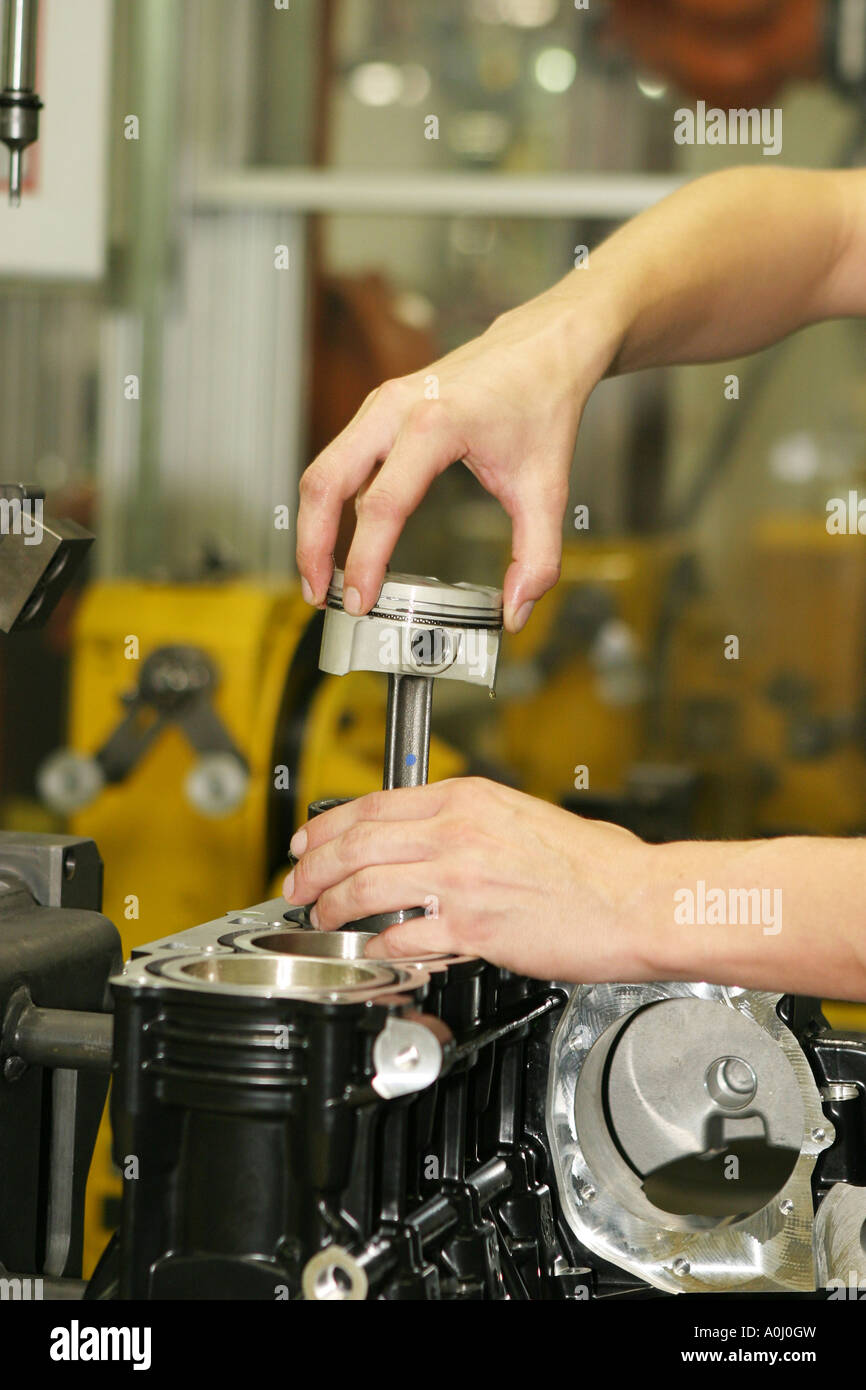 Worker puts piston into the motor Stock Photo - Alamy