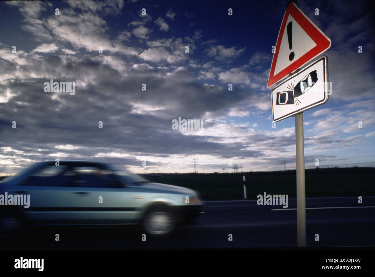 Speeding car with a sign "beware of accidents Stock Photo - Alamy