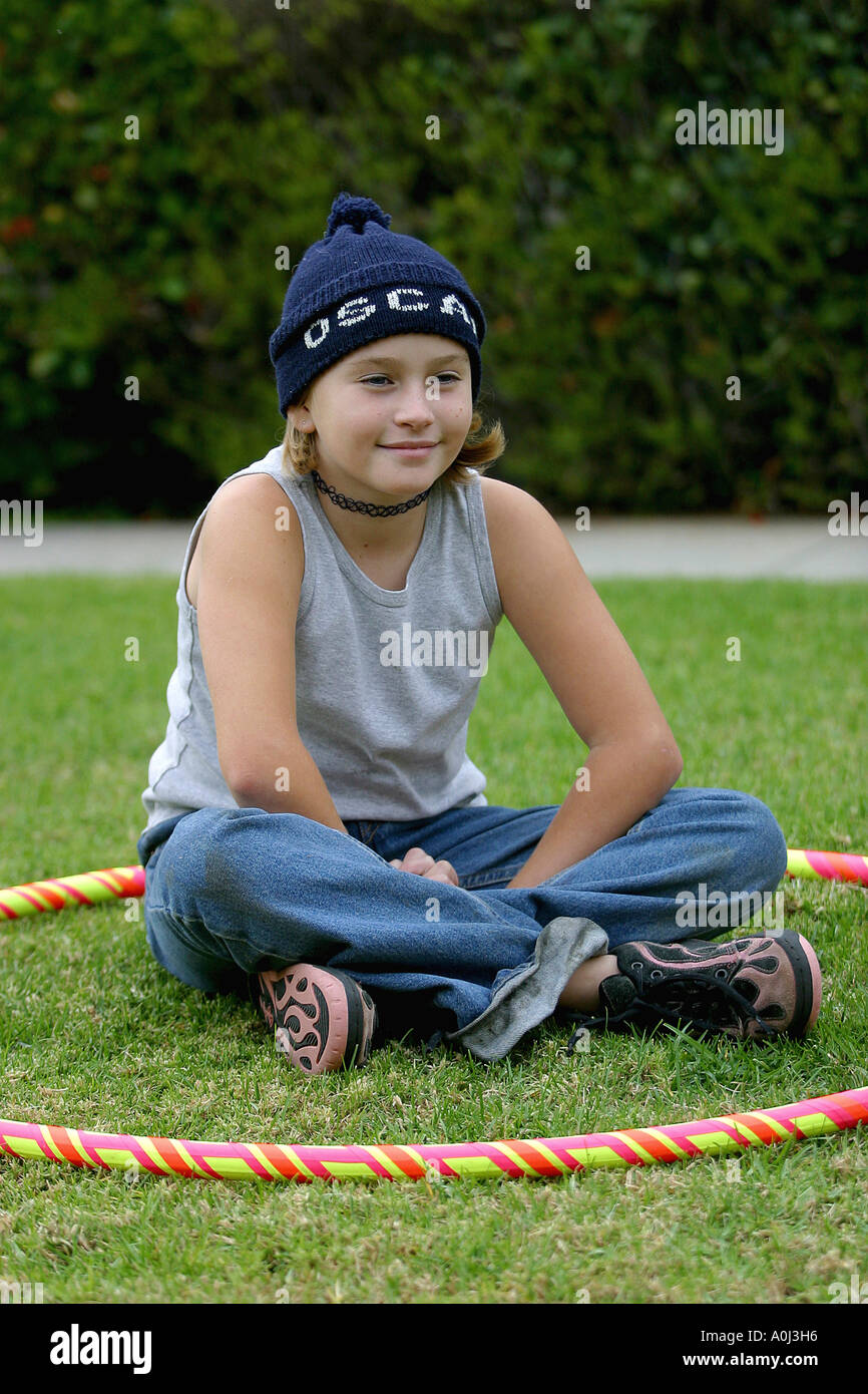 Girl sitting on a lawn in a hula hoop Stock Photo - Alamy