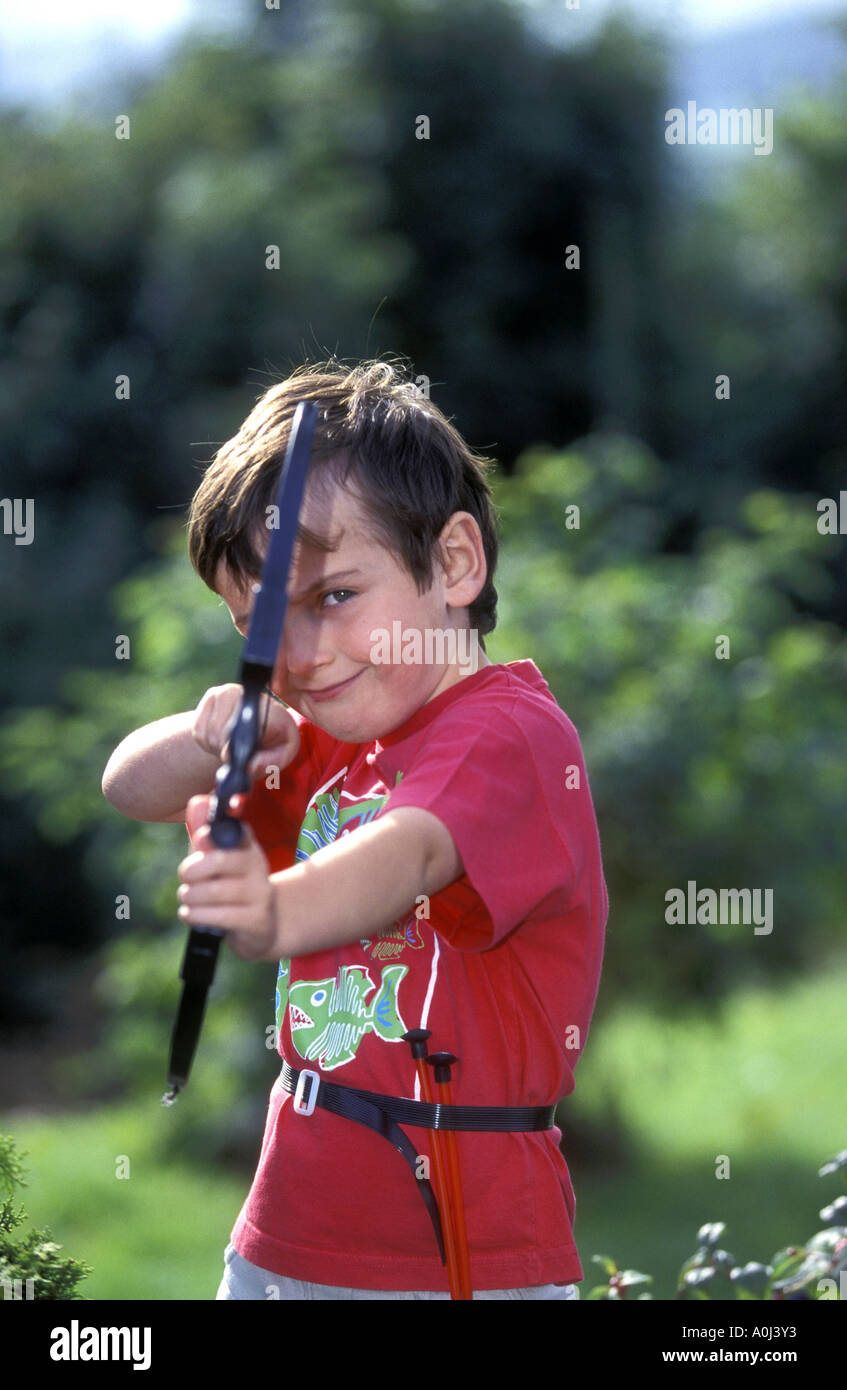 Portrait of a boy holding a bow and arrow Stock Photo - Alamy
