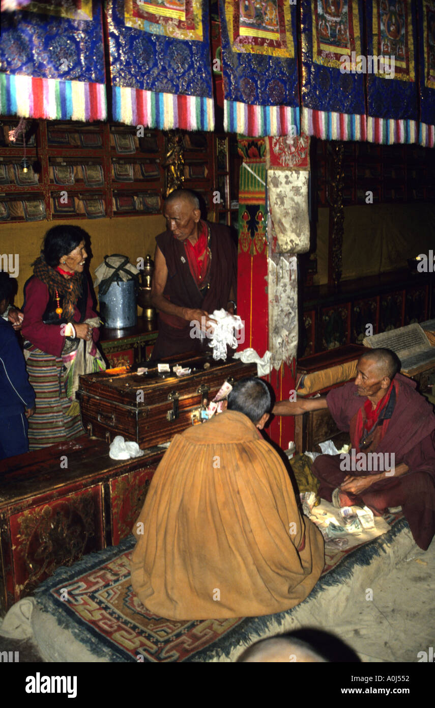 Monks counting money at entrance to monastery Stock Photo - Alamy