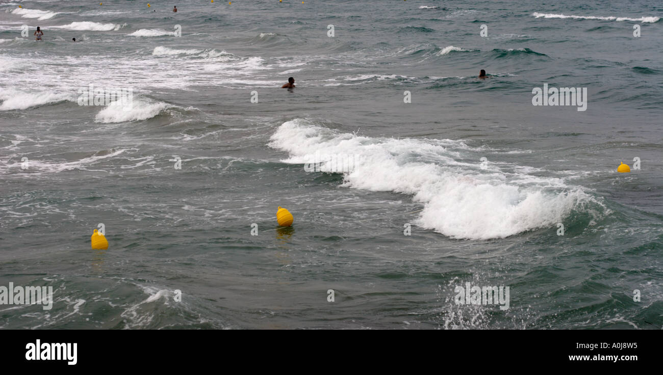 Swimmers and safety marker buoys in rough sea Stock Photo - Alamy