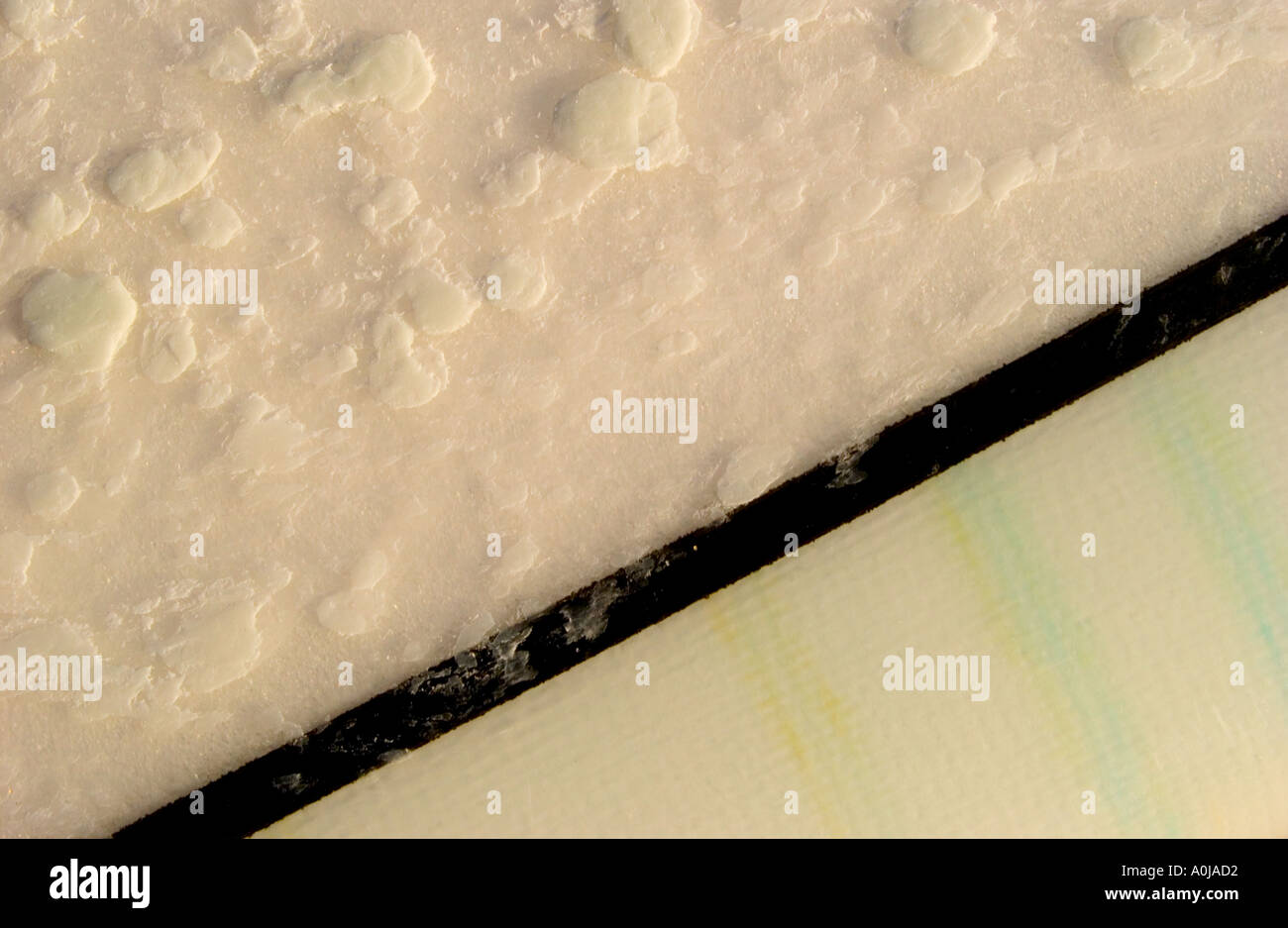 A close-up photograph of wax on a surfboard deck reveals intricate ...