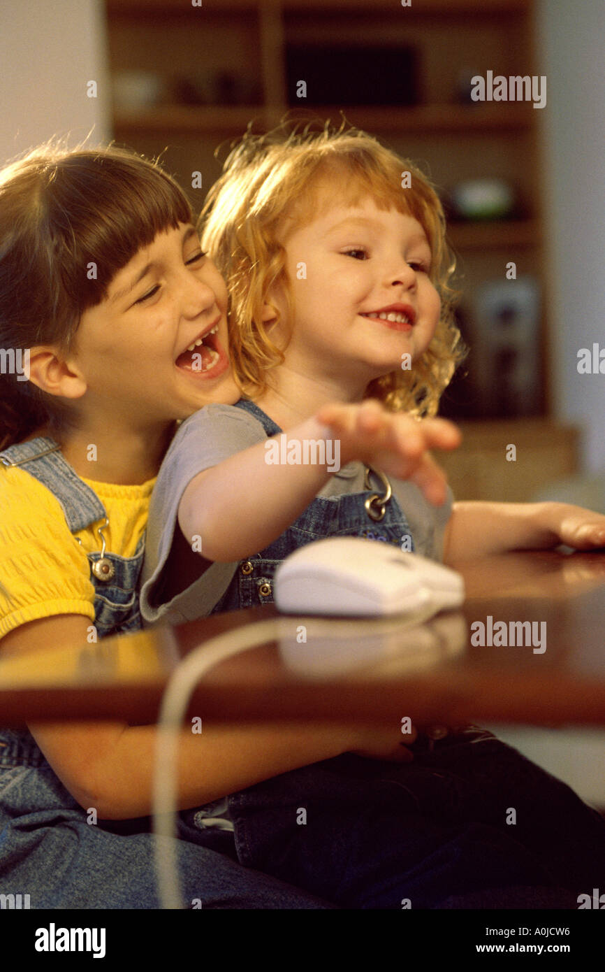 Two girls in front of a computer monitor Stock Photo - Alamy