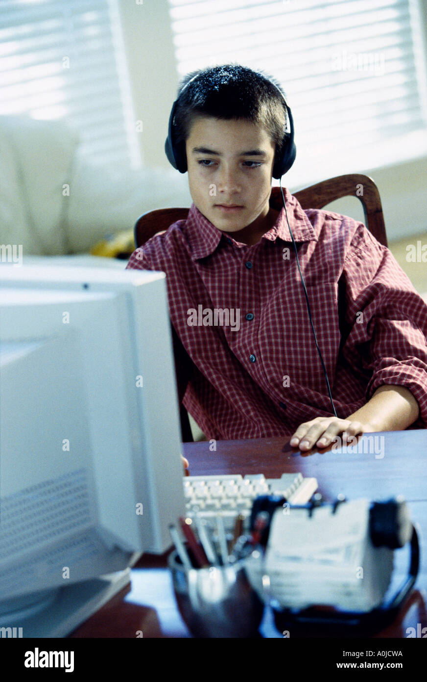 Teenage boy sitting in front of a computer monitor Stock Photo - Alamy