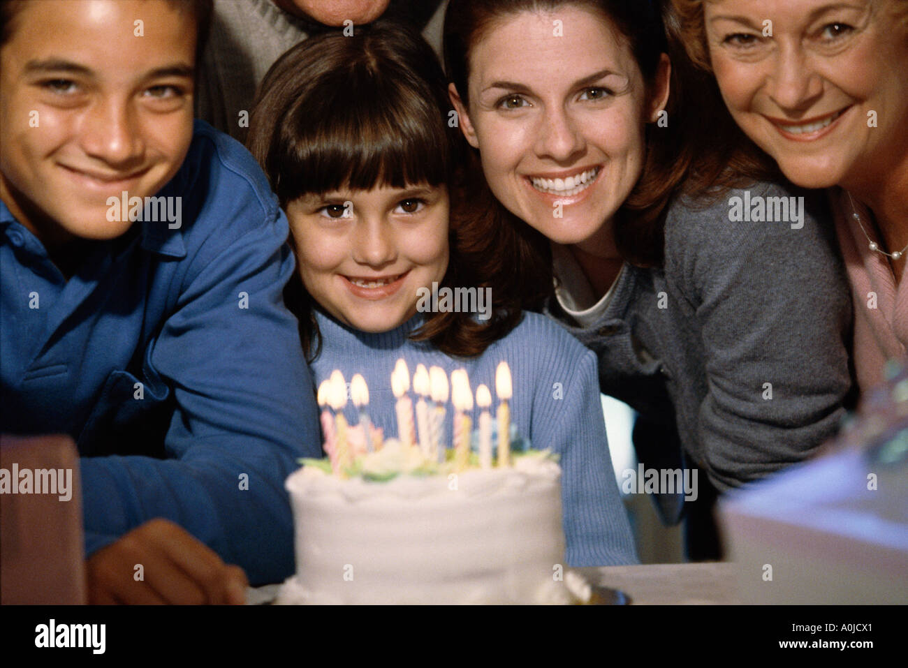 Portrait of a family smiling in front of a cake Stock Photo - Alamy