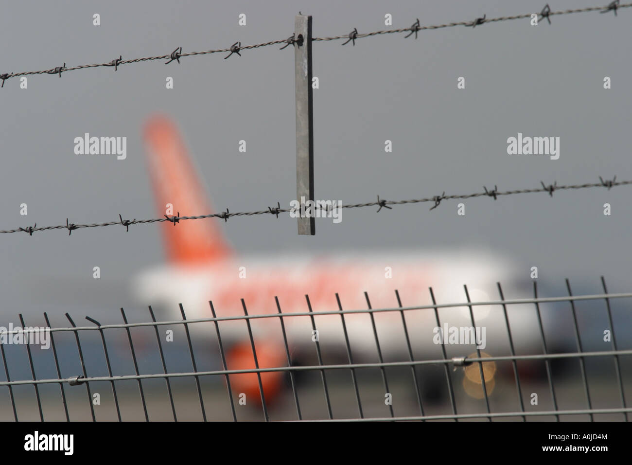 Aviation security airport perimeter fence and barbed wire with airliner ...