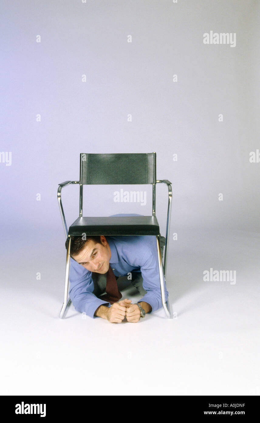 Businessman crouching under chair hi-res stock photography and images ...