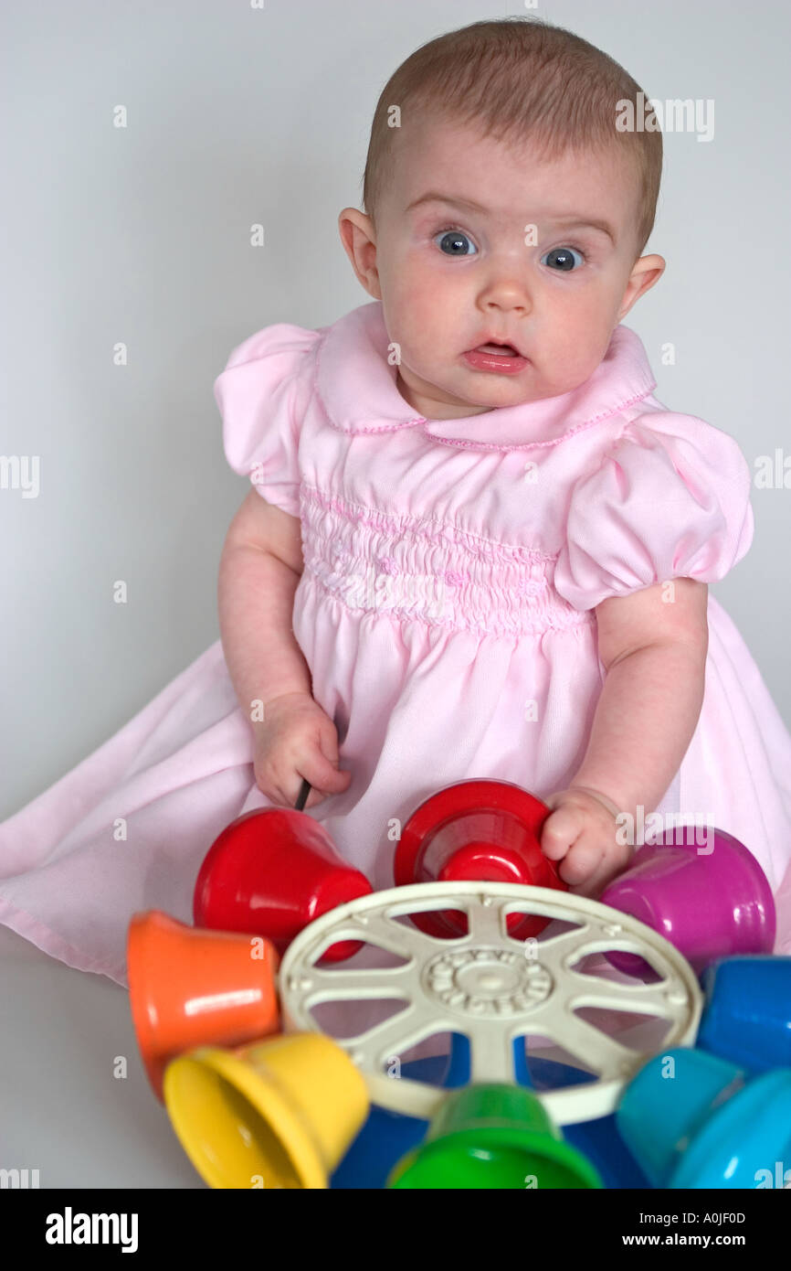 Baby girl showing surprise as she plays with musical, toy bells for the ...