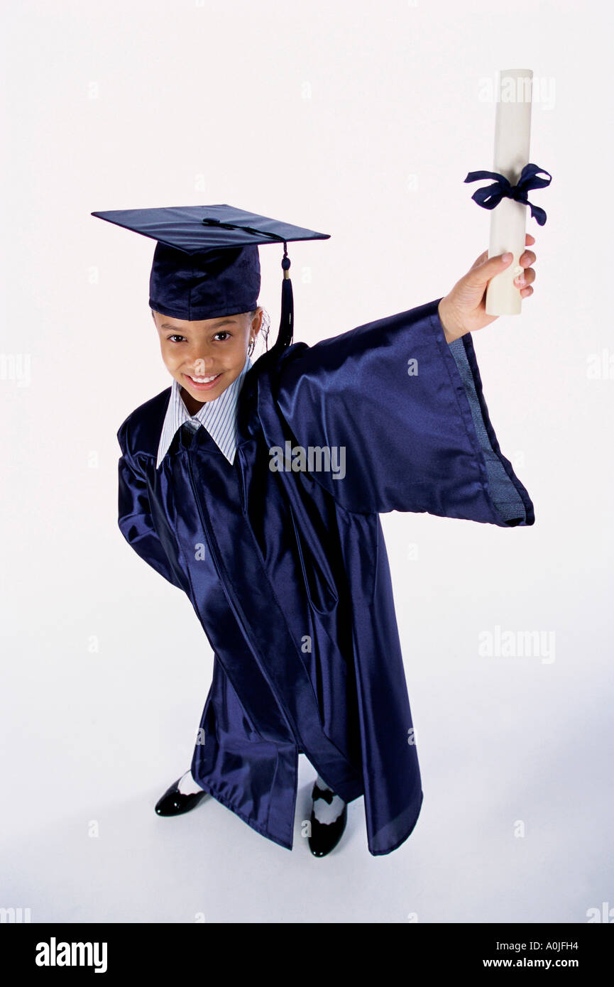 Portrait of a girl dressed in a graduation outfit holding a diploma ...
