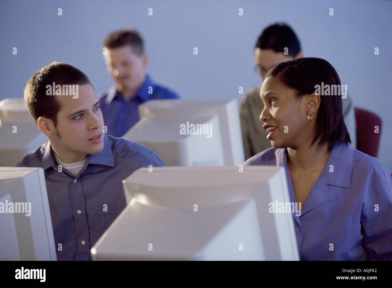People sitting in front of computer monitors Stock Photo - Alamy