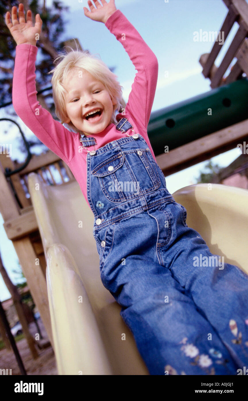 Portrait of a girl sliding down a slide Stock Photo - Alamy