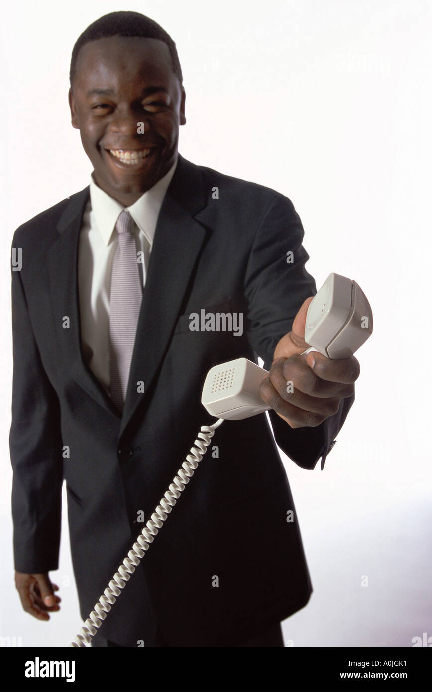 Portrait of a businessman holding a telephone receiver Stock Photo - Alamy