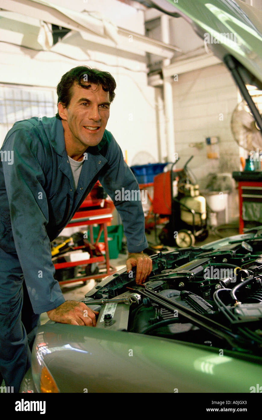 Auto mechanic working over the engine bay of a car Stock Photo - Alamy